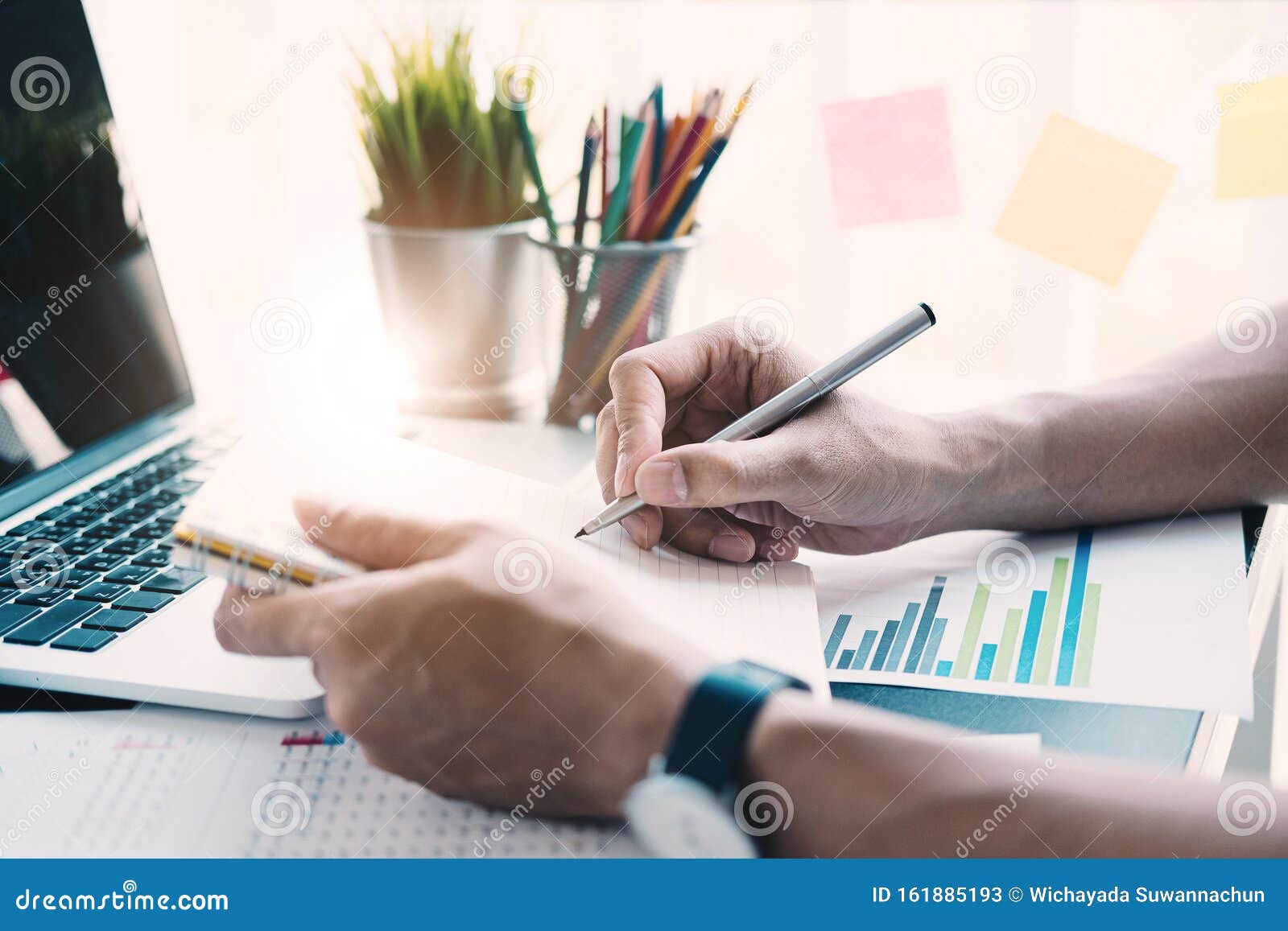 Man Using Computer and Calculator during Note Some Data on Notepad for ...