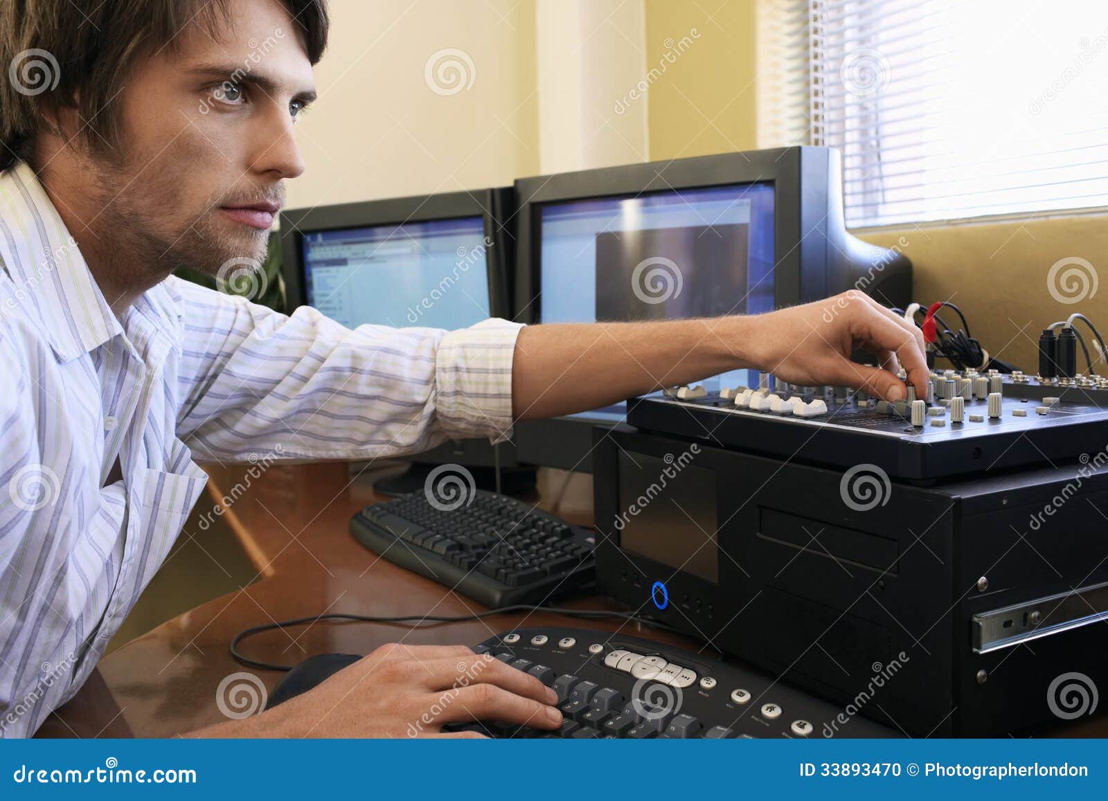 Man Using Computer Keyboard and Adjusting Knob on Mixer Stock Photo ...
