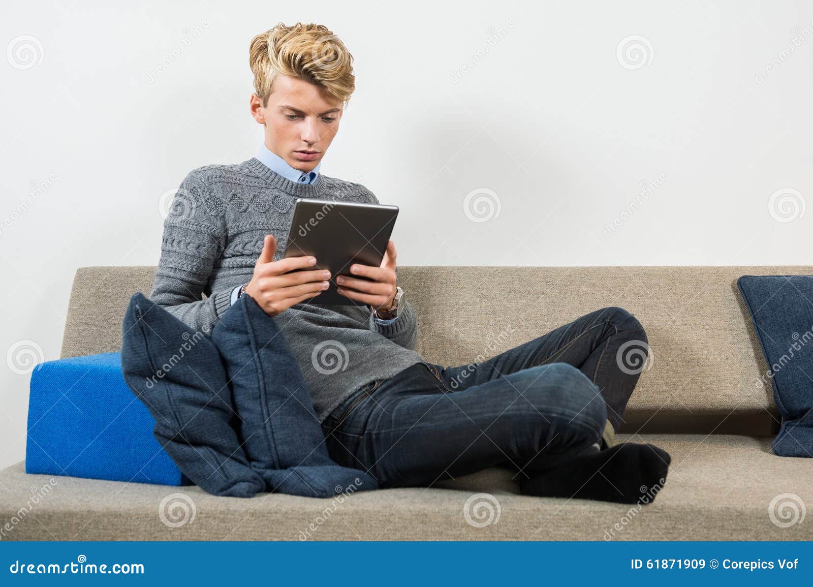 Man Using Digital Tablet on Sofa at Home Stock Image - Image of house ...