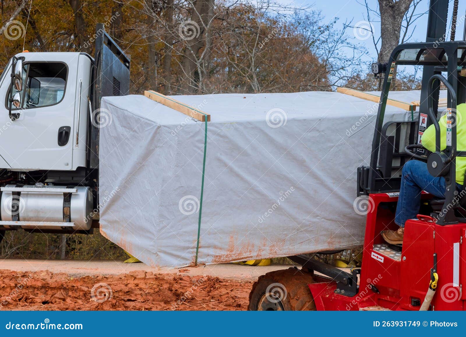 Man Using a Forklift Working on Unloading the Construction Parts of the ...