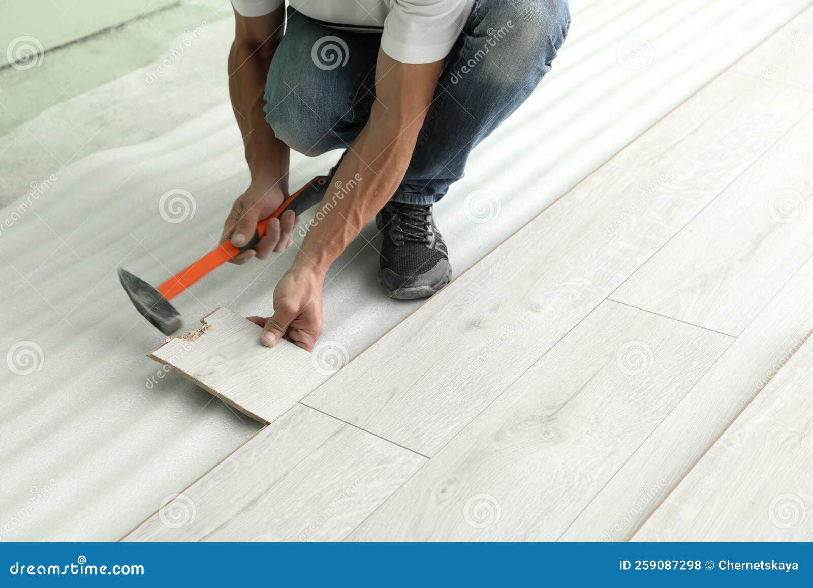 Man Using Hammer during Installation of New Laminate Flooring, Closeup ...