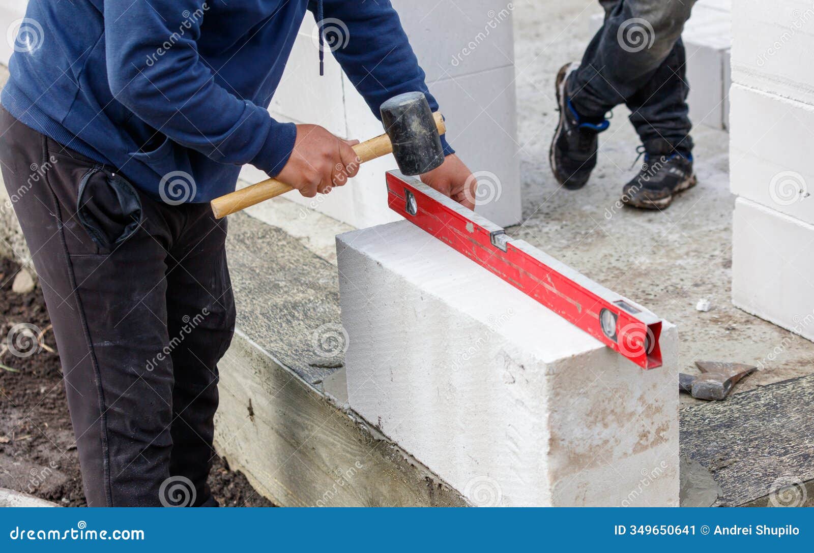 A Man is Using a Hammer and a Level To Build a Wall Stock Image - Image ...