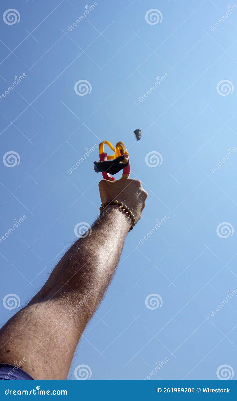 Man Using a Handmade Rubber Slingshot Against a Blurred Background ...