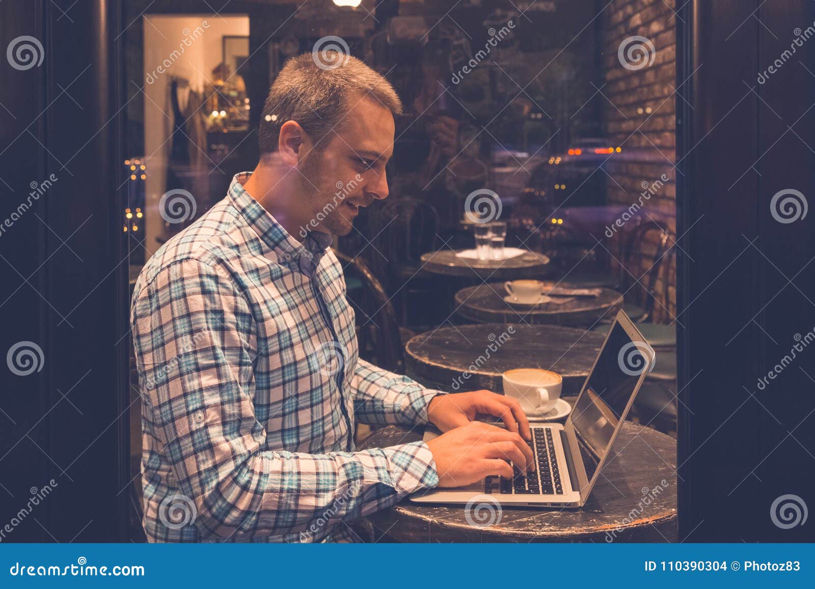Man using laptop in cafe stock photo. Image of person - 110390304