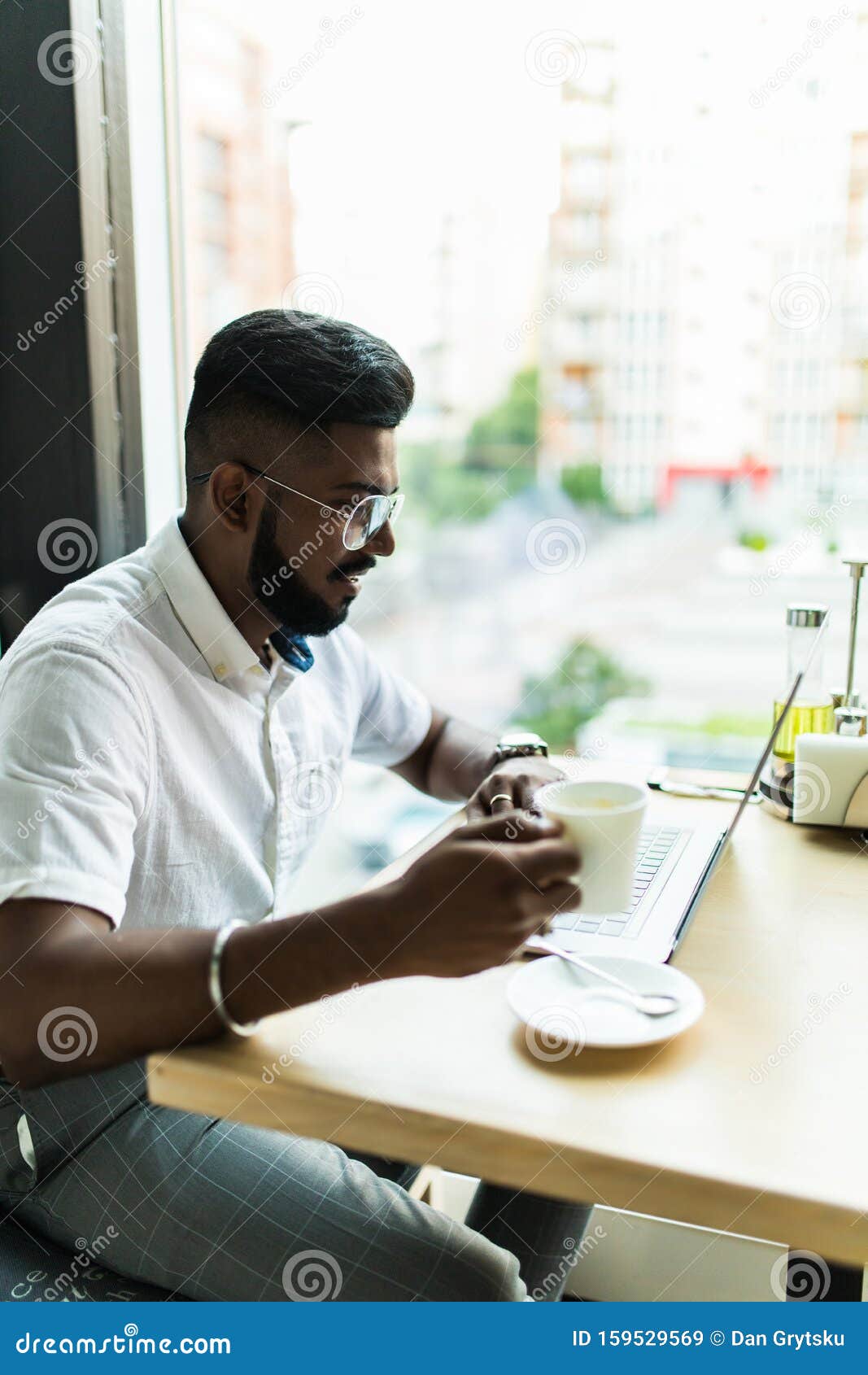 Indian Man Using Laptop Computer while Drinking a Cup Hot Milk Tea ...
