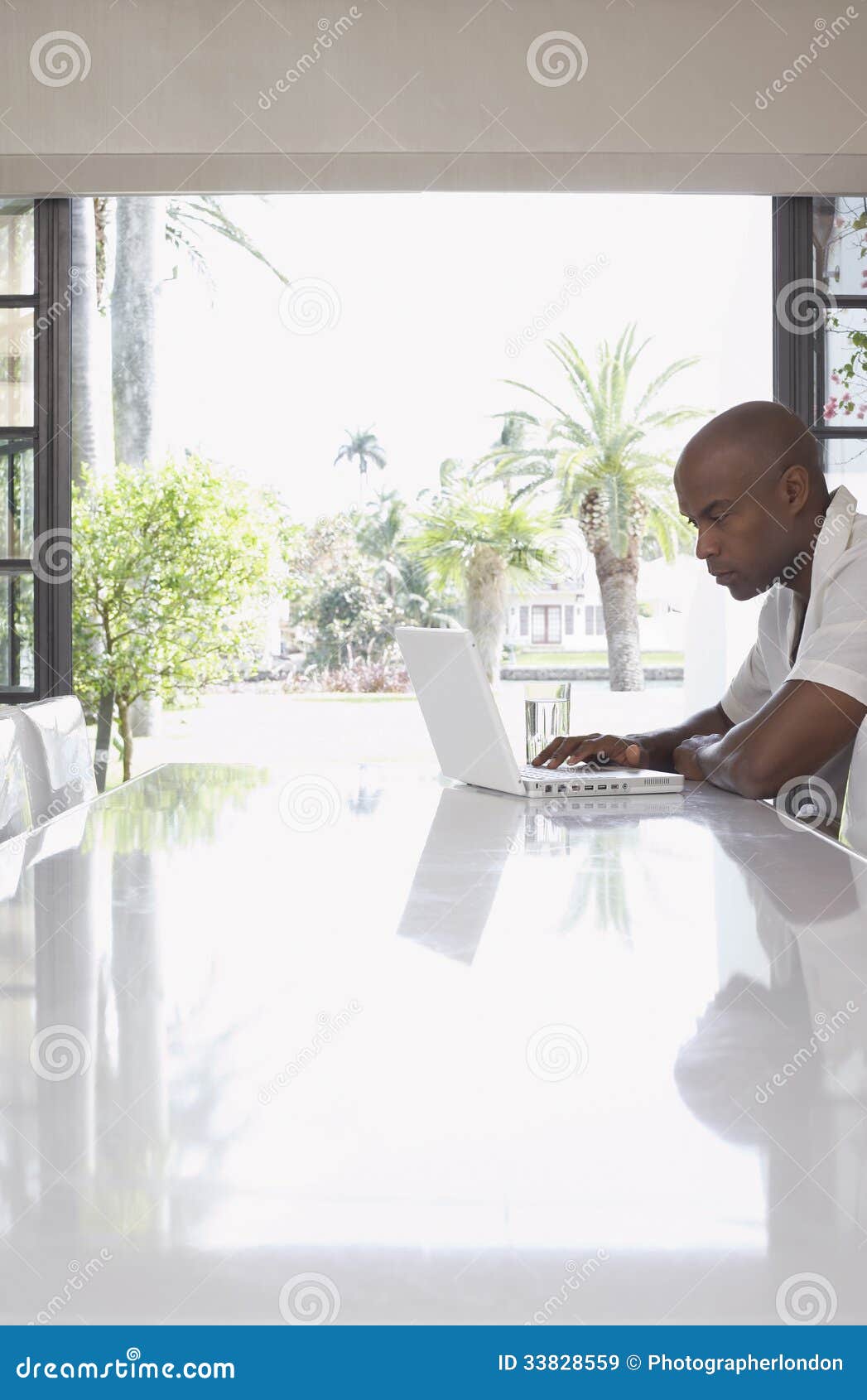 Man Using Laptop at Dining Table Stock Image - Image of garden, people ...