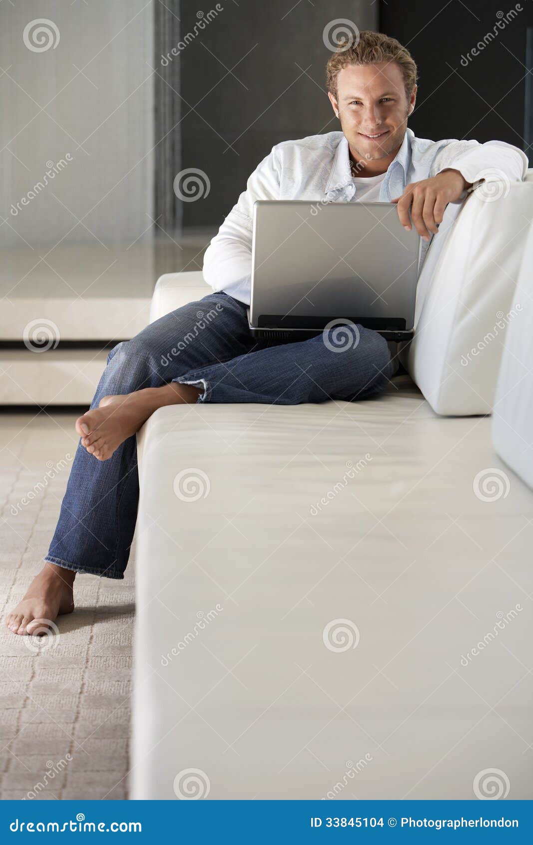 Man Using Laptop on Sofa stock photo. Image of computer - 33845104