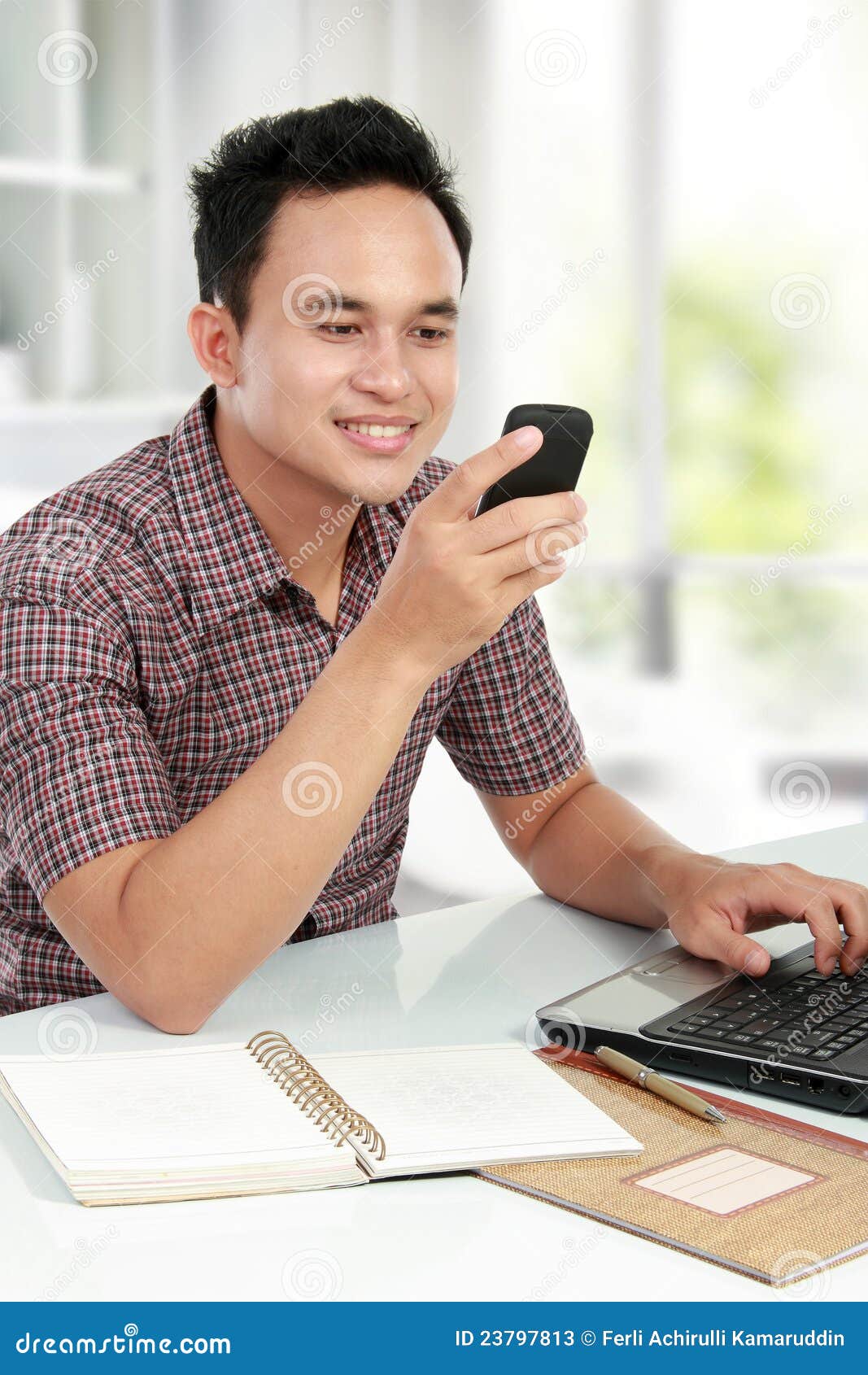 Man Using a Laptop and Texting on Mobile Phone Stock Image - Image of ...