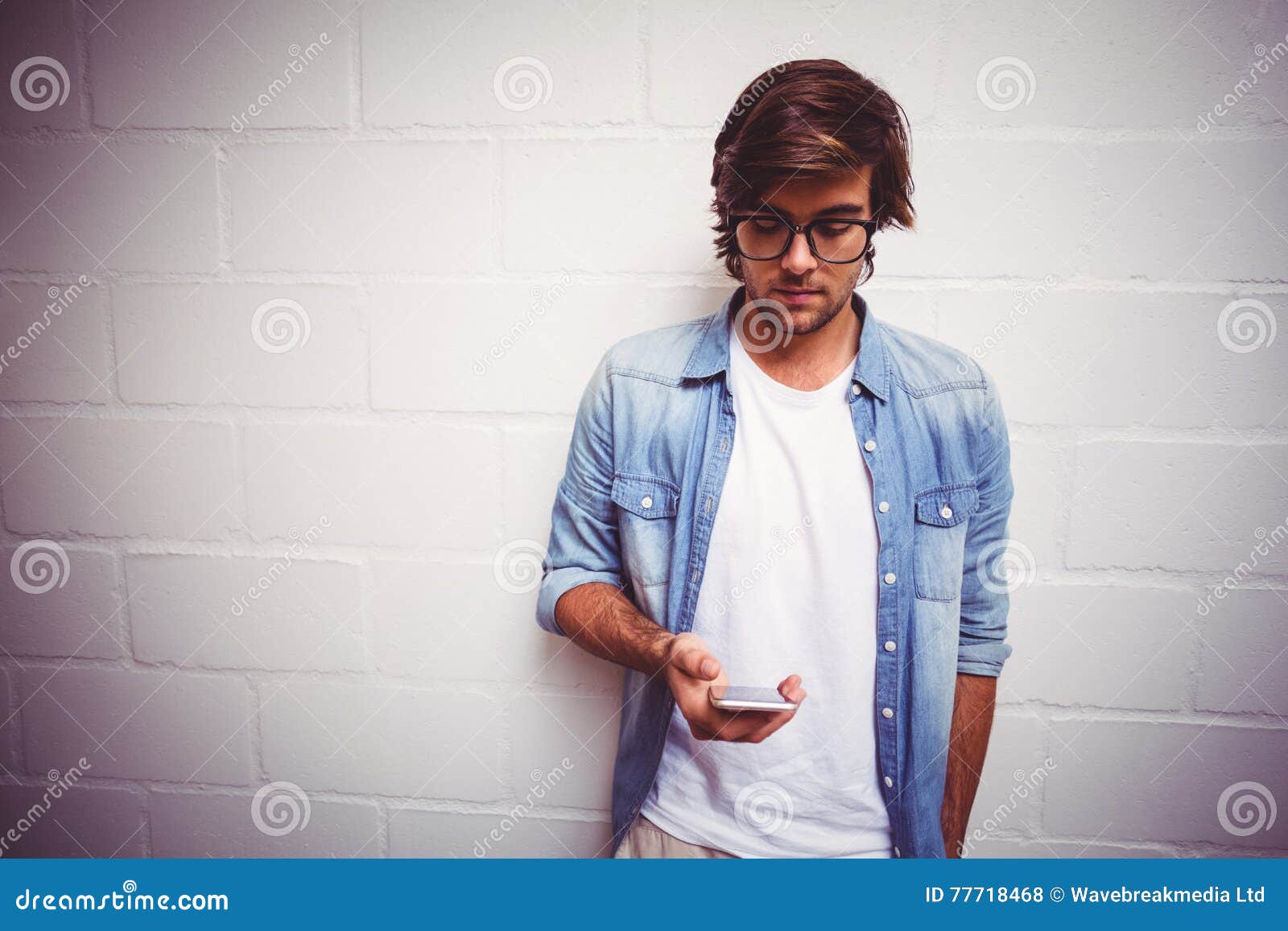Man Using Mobile Phone Against Wall Stock Photo - Image of front ...