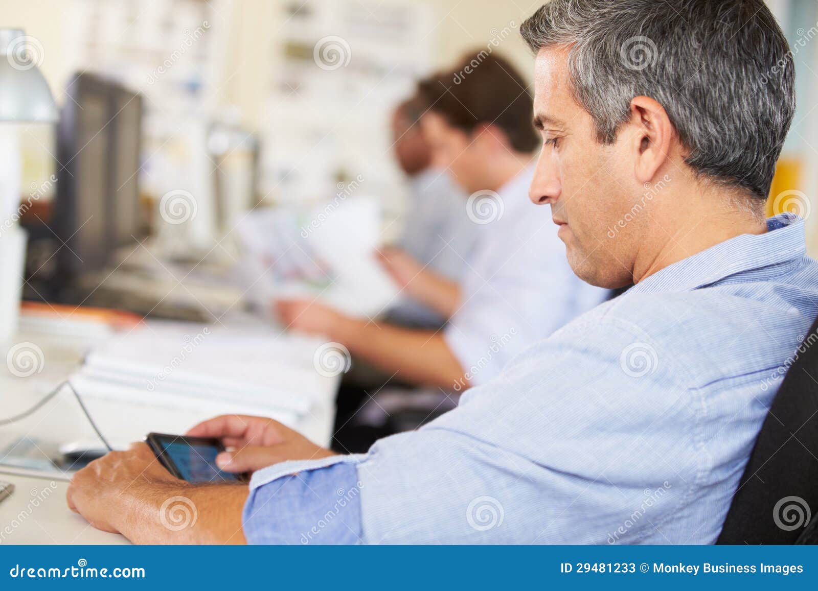 Man Using Mobile Phone at Desk in Busy Creative Office Stock Image ...