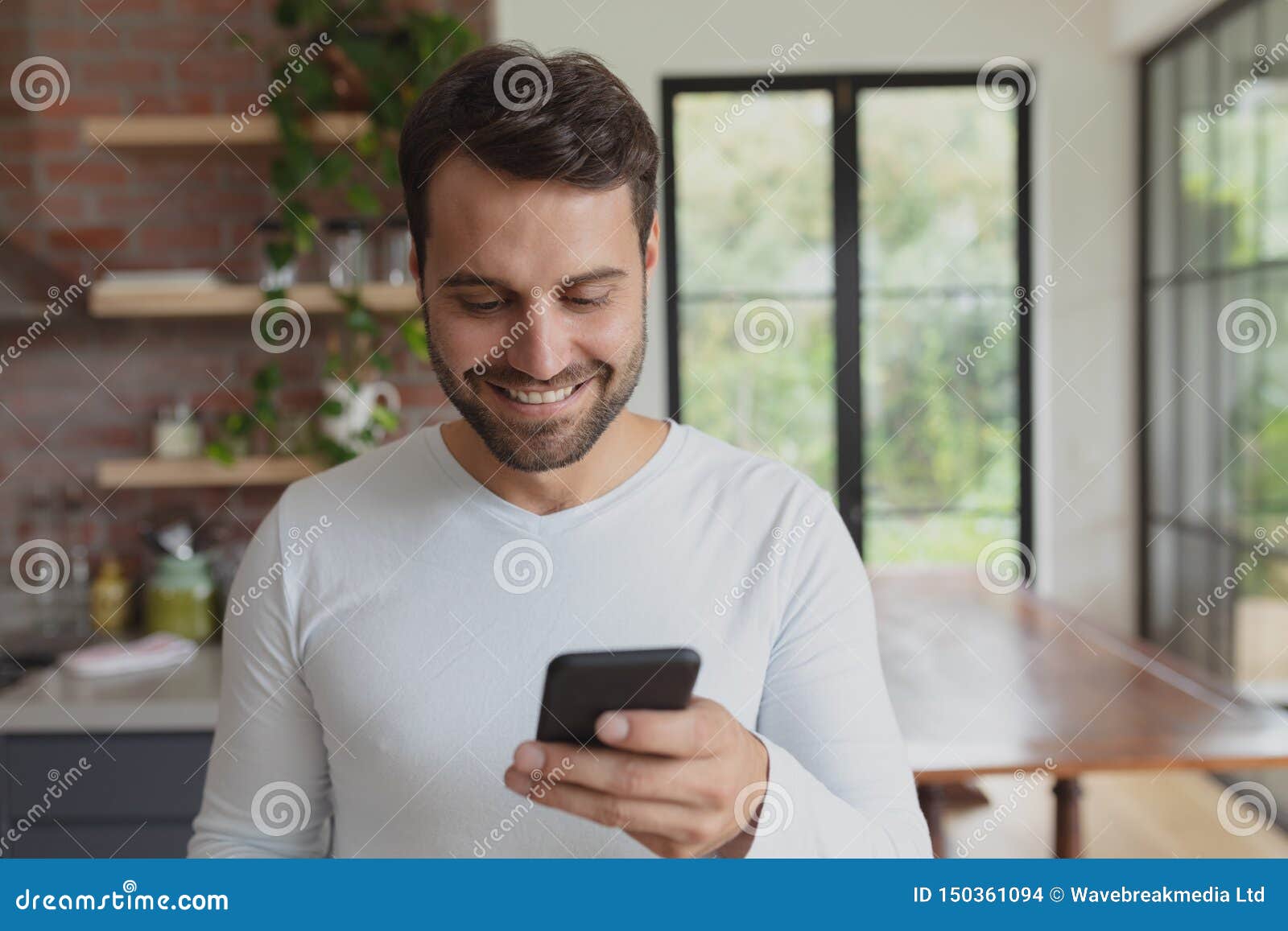 Man Using Mobile Phone in Kitchen at Home Stock Photo - Image of ...