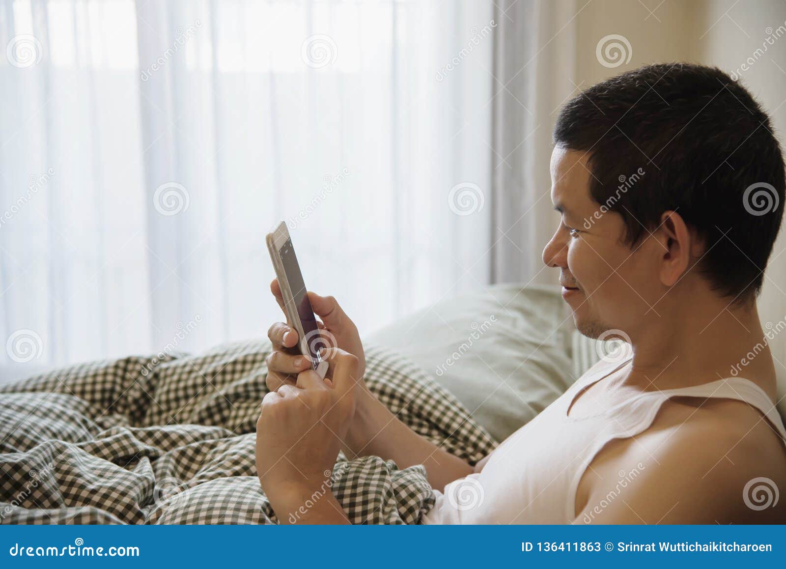 Man Using Mobile Phone while Wake Up on Bed in the Morning Stock Image ...