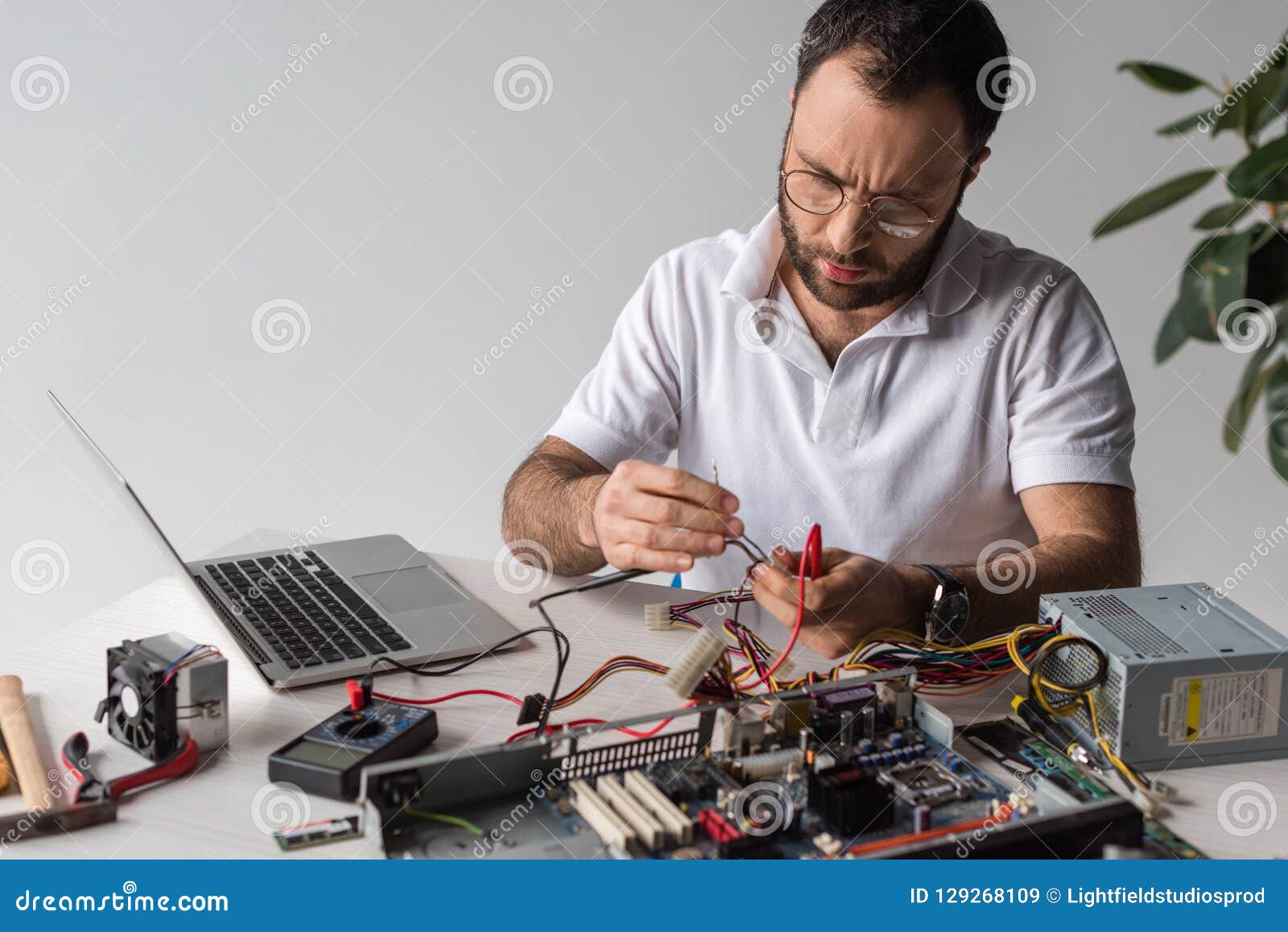 Man Using Multimeter while Fixing Broken Computer and Looking Down ...