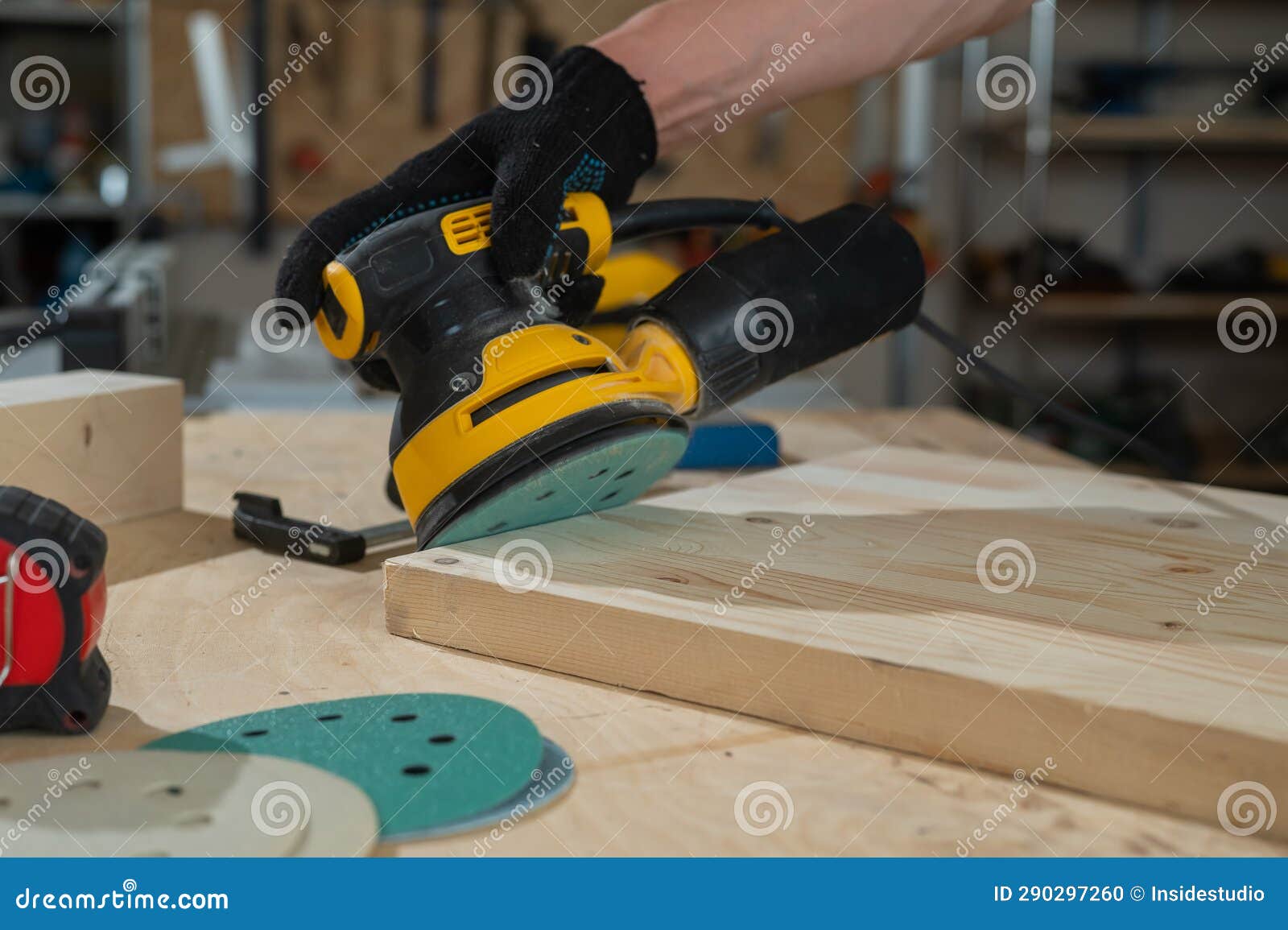 A Man Using an Orbital Wood Sander in a Workshop. Close-up of a ...