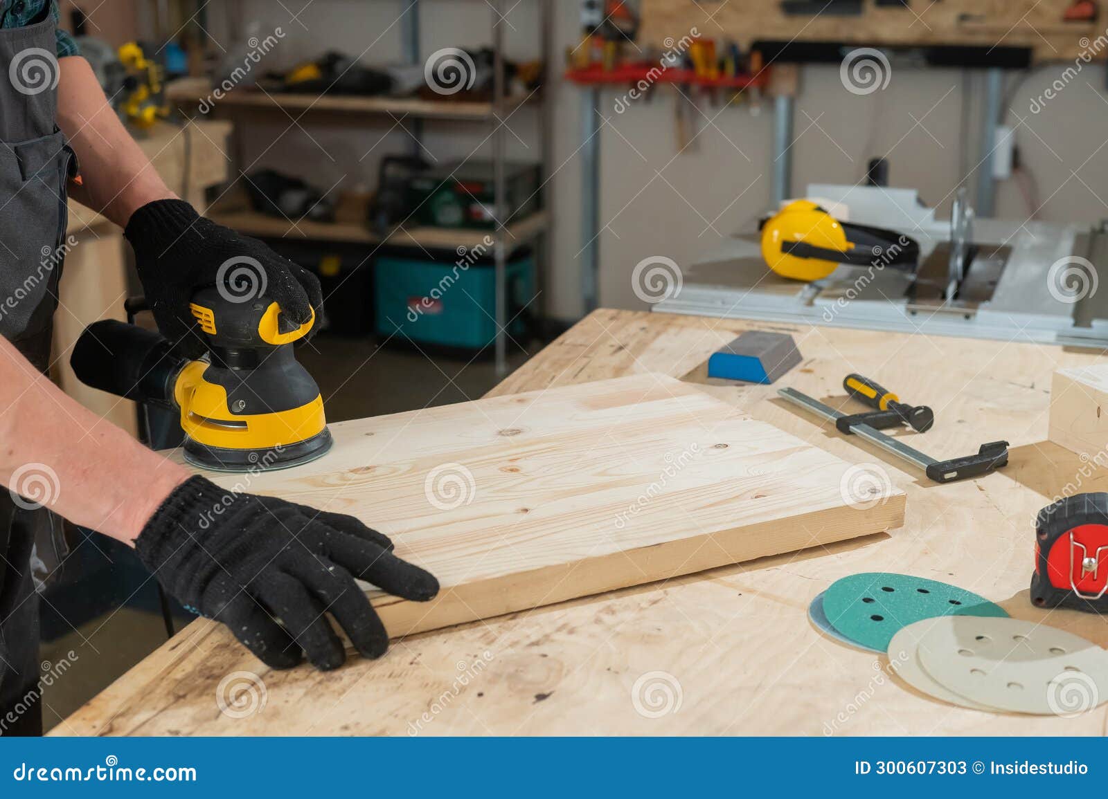 A Man Using an Orbital Wood Sander in a Workshop. Close-up of a ...