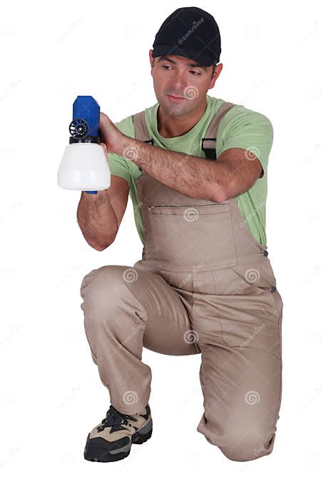 Man using paint sprayer stock photo. Image of kneeling - 30483046