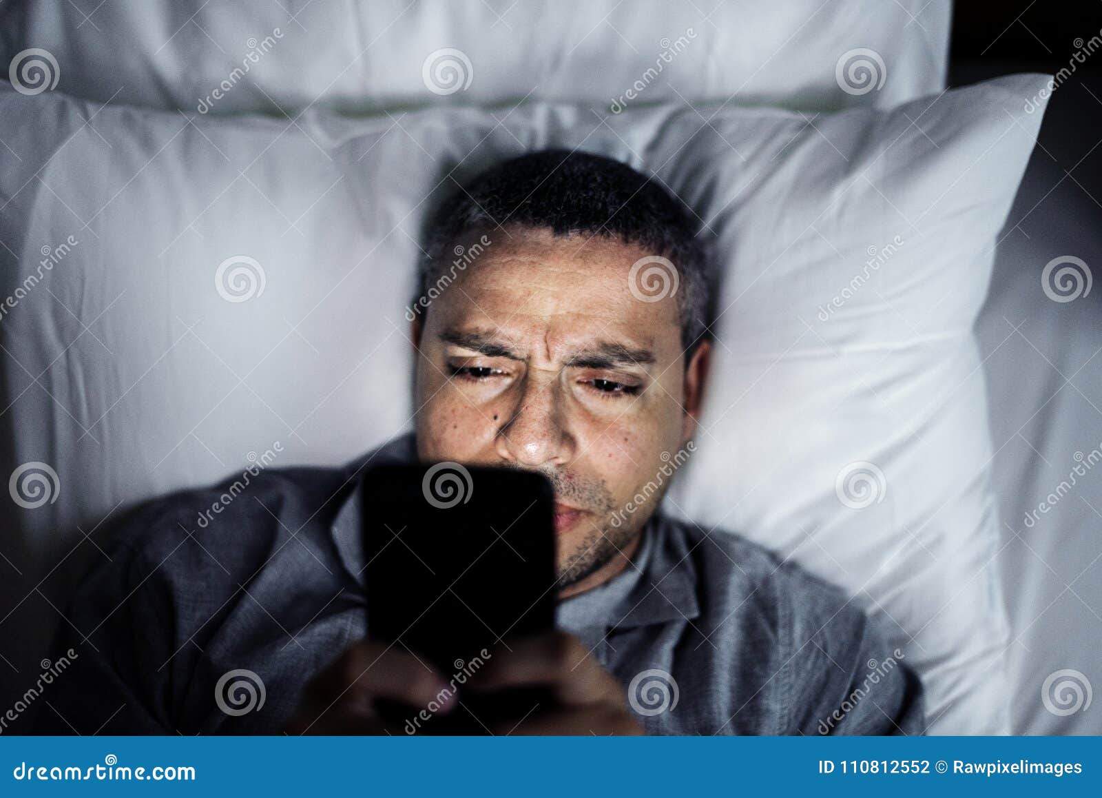Man using phone on a bed stock photo. Image of dwell - 110812552