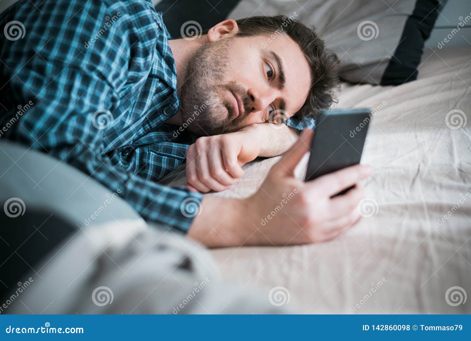 Man Using Phone Lying on the Bed Stock Photo - Image of insomnia, chat ...