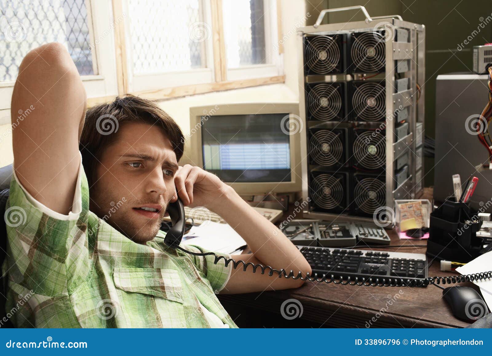 Man Using Phone Surrounded by Computer Equipment Stock Photo - Image of ...
