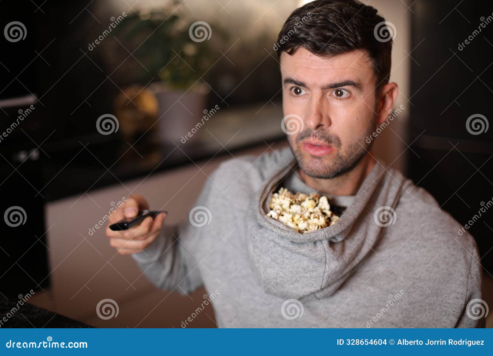 Man Using Remote Control while Enjoying His Popcorn Stock Photo - Image ...