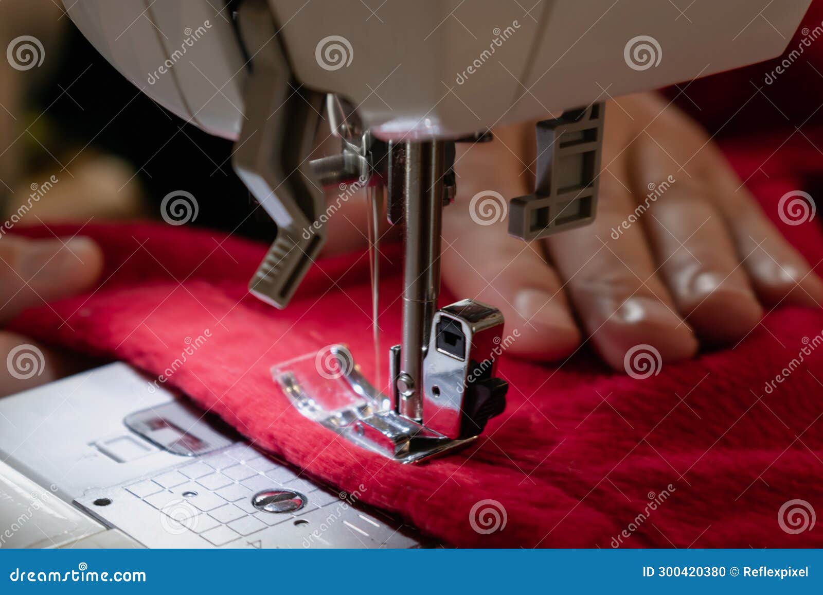 Man Using a Sewing Machine with a Red Garment, for Repair Work ...