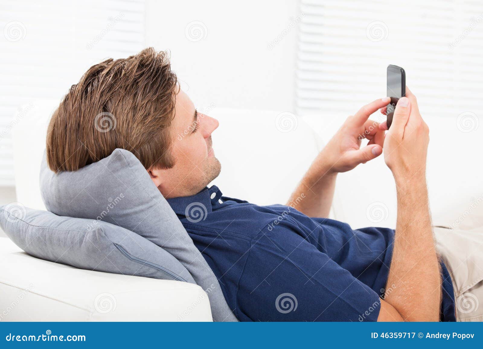 Man Using Smart Phone on Sofa Stock Image - Image of looking, person ...