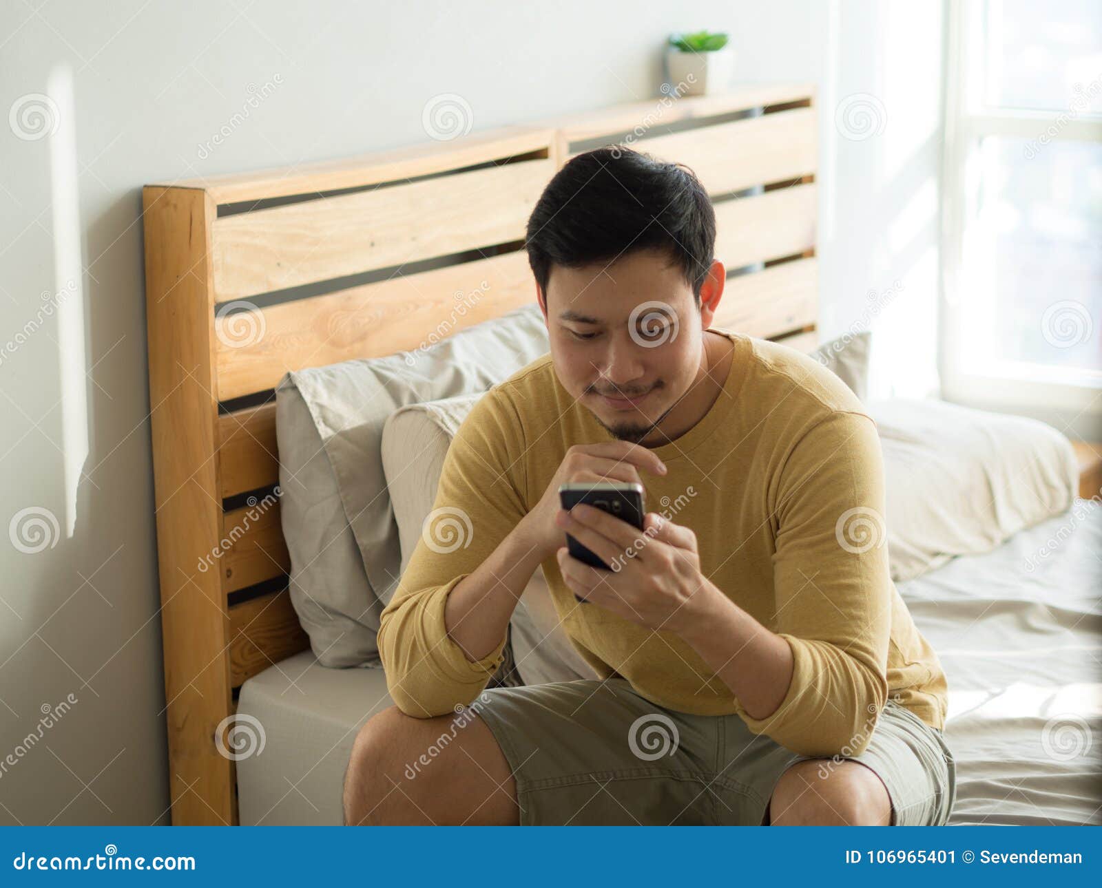 Man Using Smartphone in His Bed in the Morning. Stock Image - Image of ...