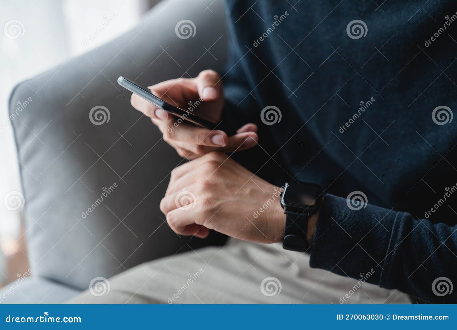 Man Using Smartphone and Smartwatch for Tracking Activity on Sofa in ...