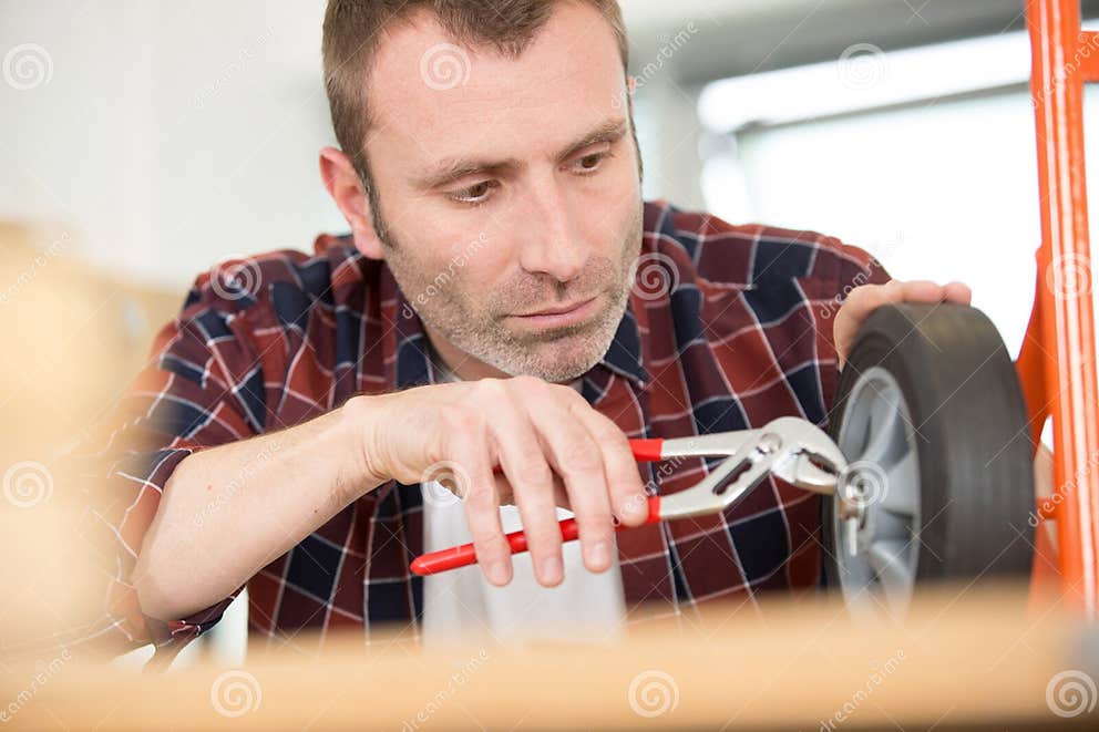 Man Using Spanner To Fix Trolley Wheel Stock Photo - Image of swivel ...
