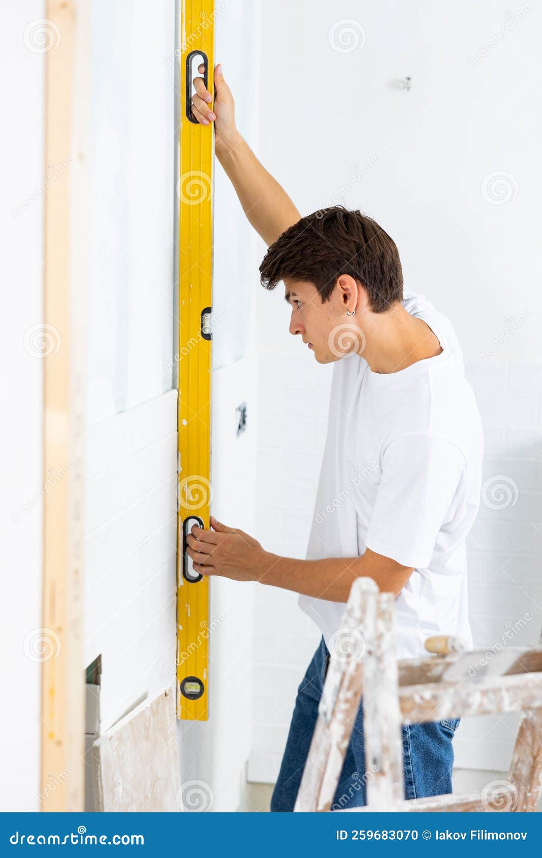 Man Using Building Level on Wall in Apartment, Measuring Flatness of ...