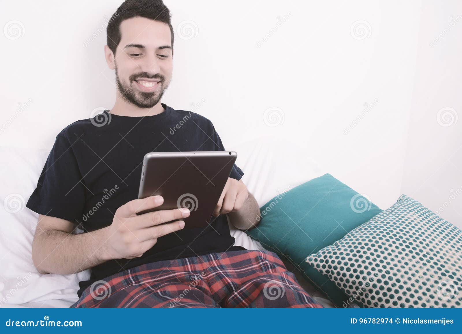 Man using tablet on bed. stock photo. Image of adult - 96782974