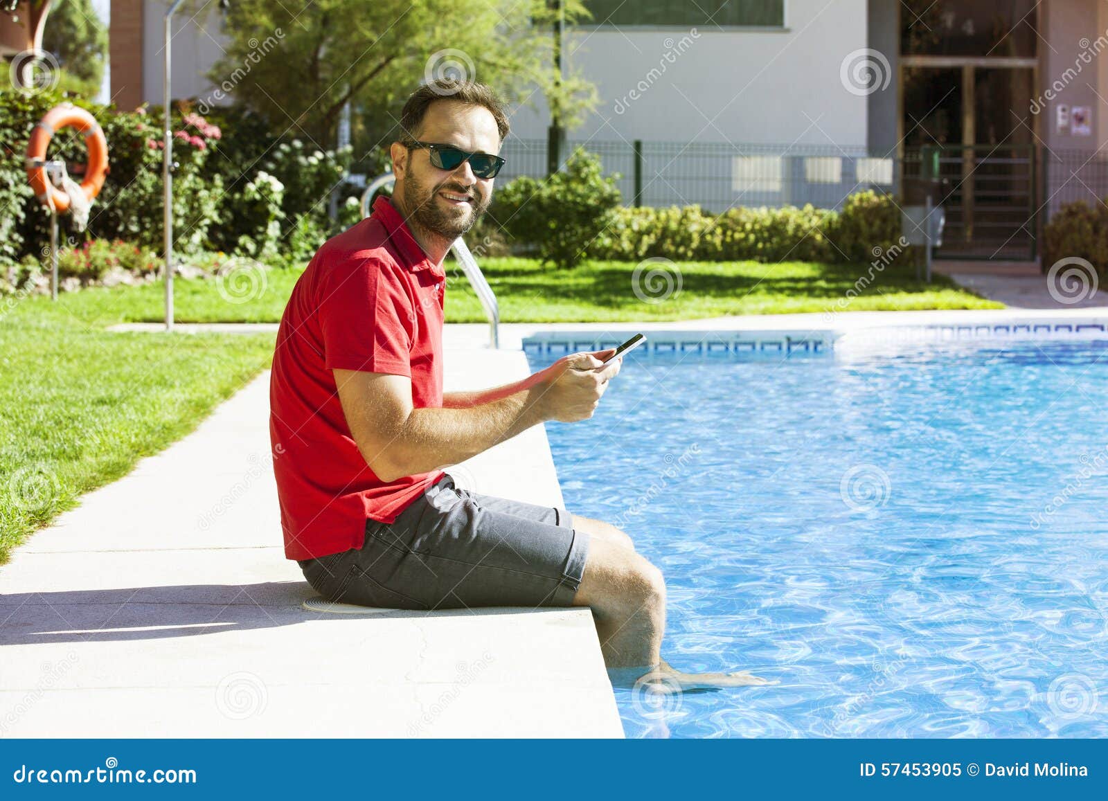 Man Using Tablet Sitting on the Poolside. Stock Image - Image of ...