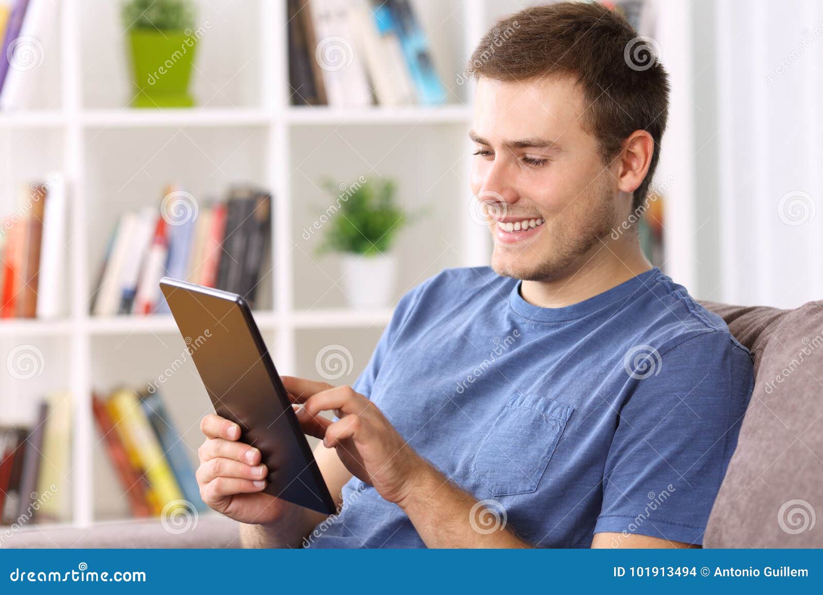 Man Using a Tablet on a Sofa at Home Stock Photo - Image of device ...