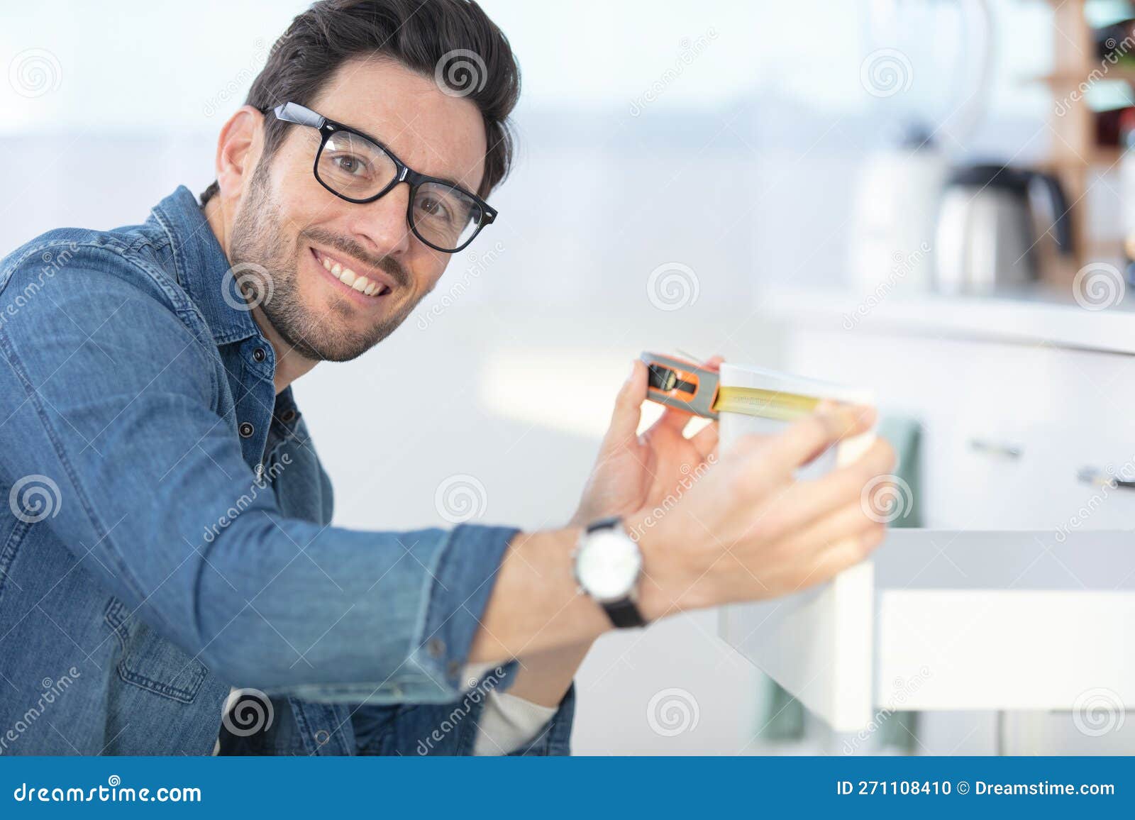 Man Using Tape Measure for Measuring Drawer in Kitchen Stock Photo ...