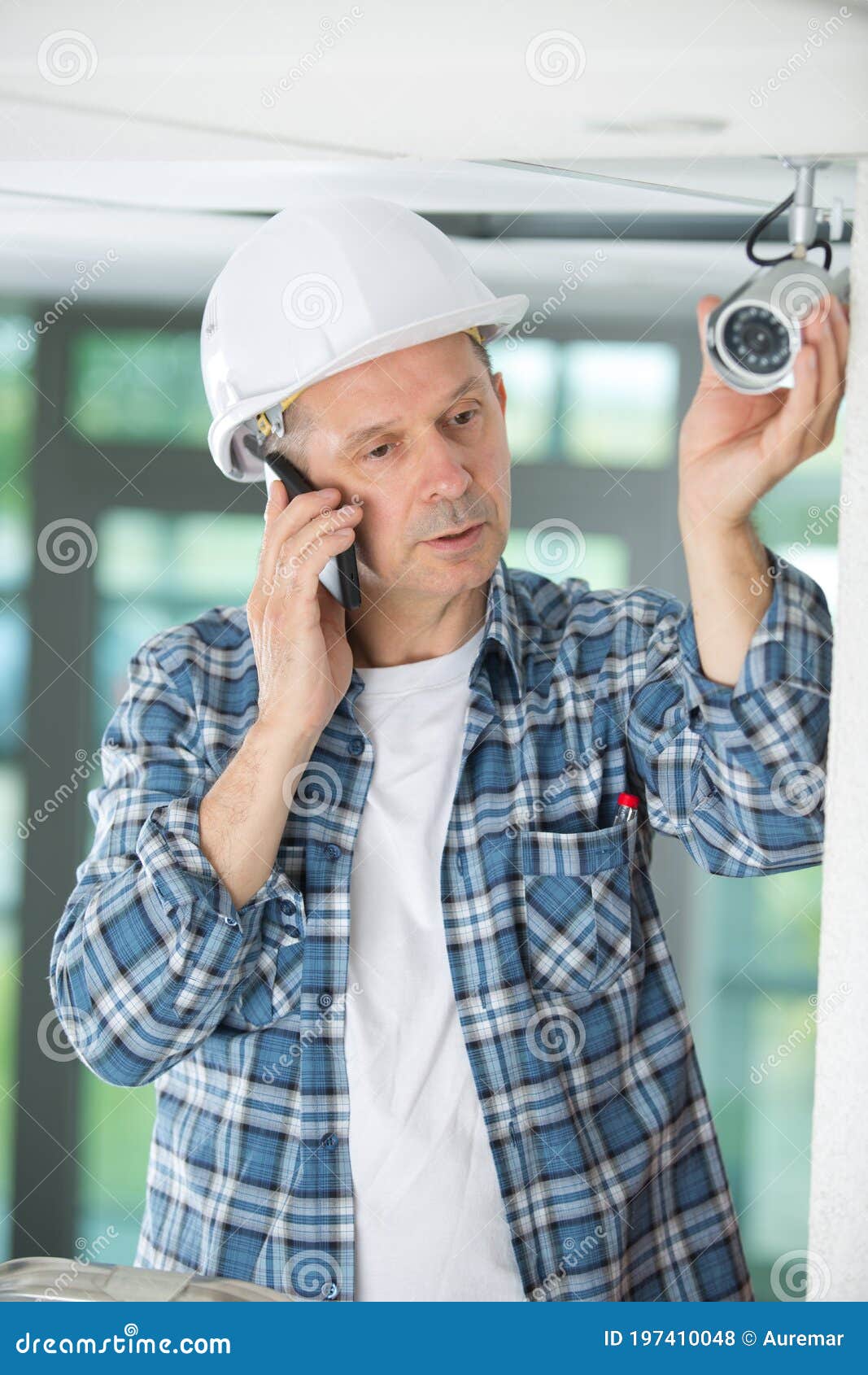 Man Using Telephone while Working on Security Camera Stock Photo ...