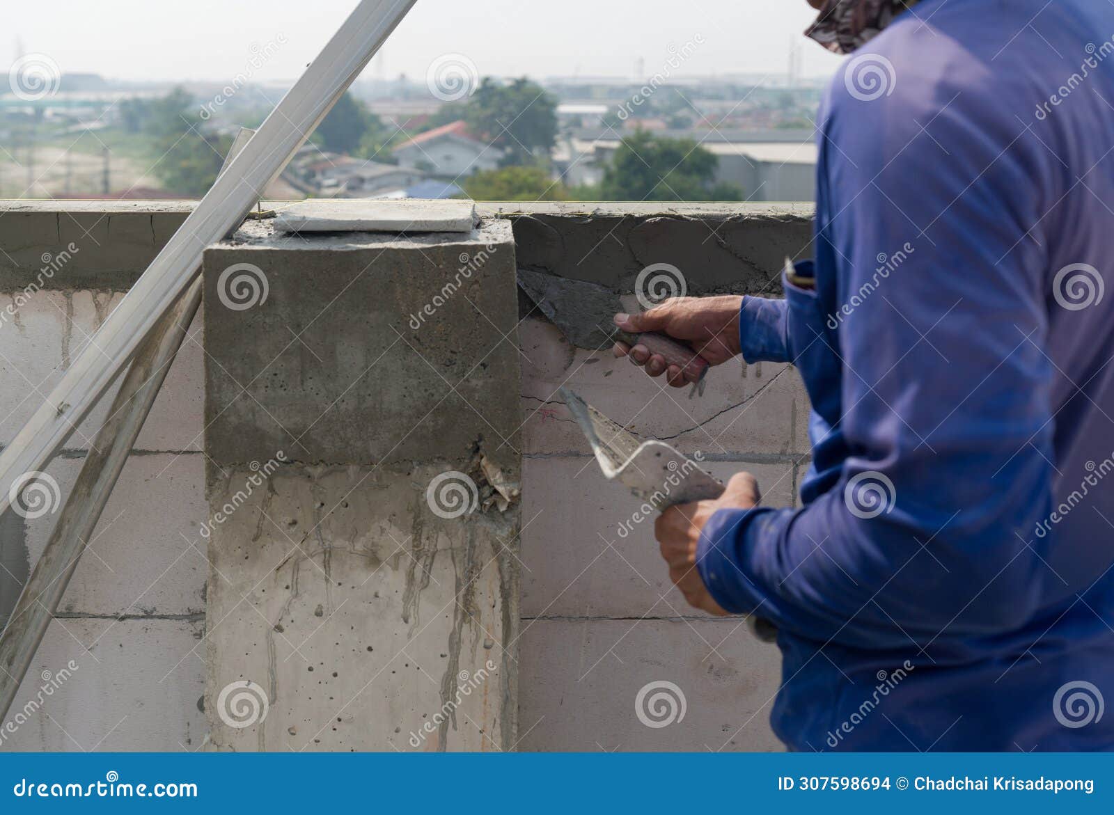 A Man is Using Tools To Work on a Concrete Wall at a Construction Site ...