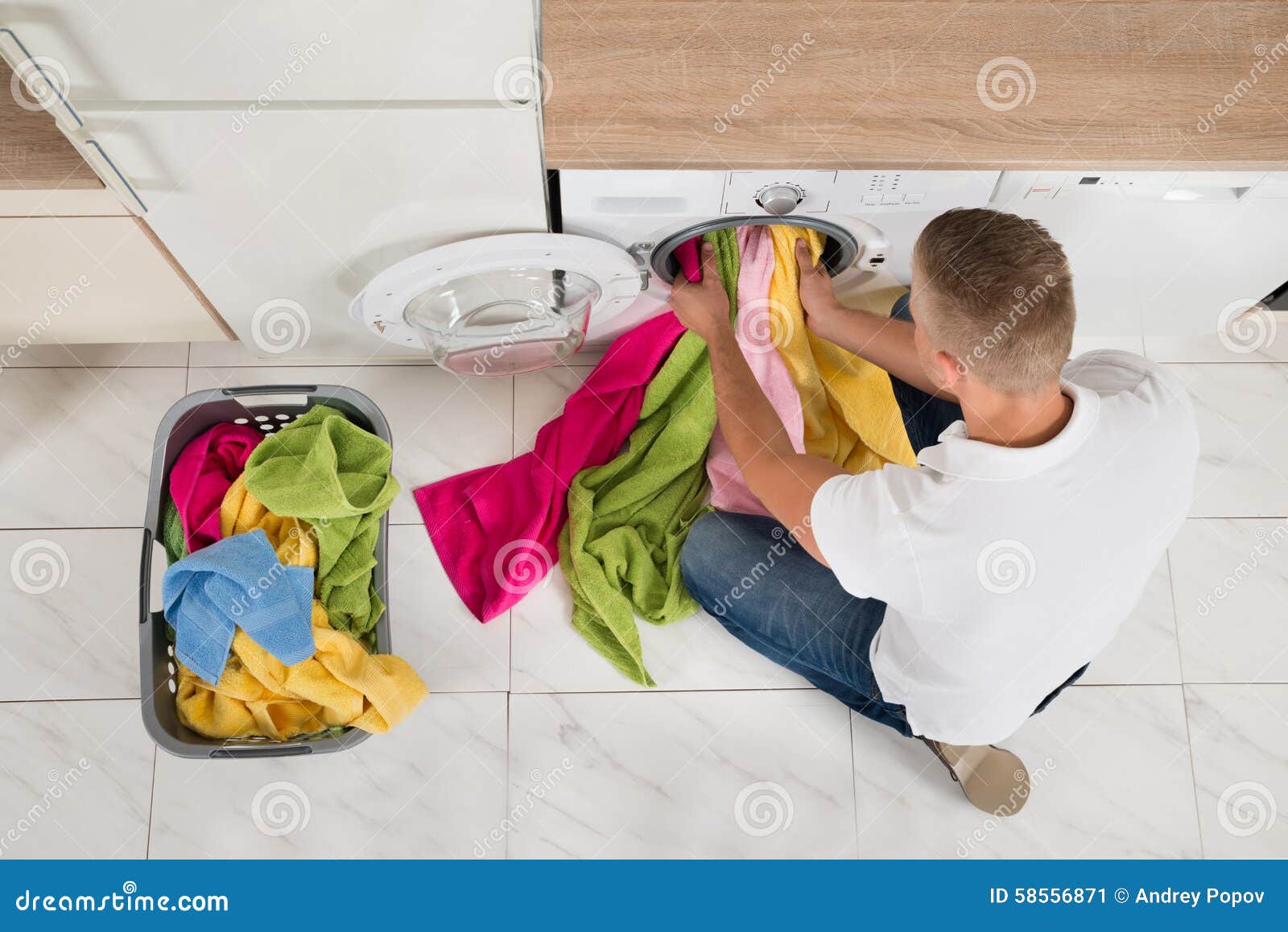 Man Using Washing Machine stock image. Image of kneeling - 58556871