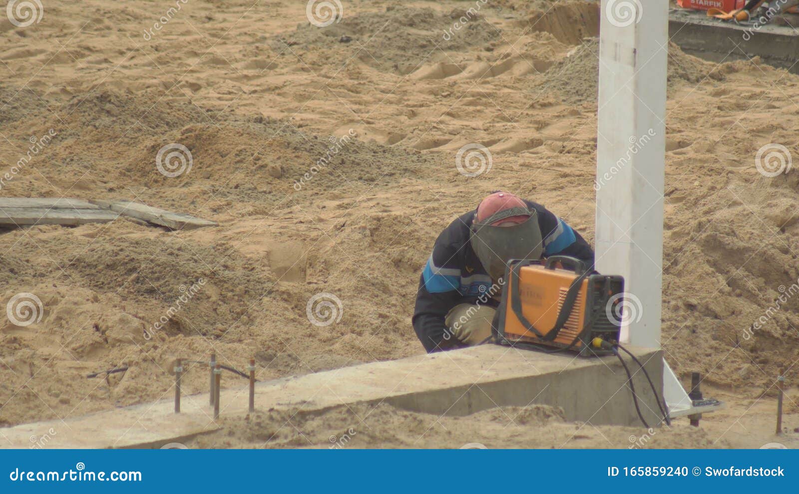 A Man Using a Welding Machine Welds Metal Surfaces at a Construction ...