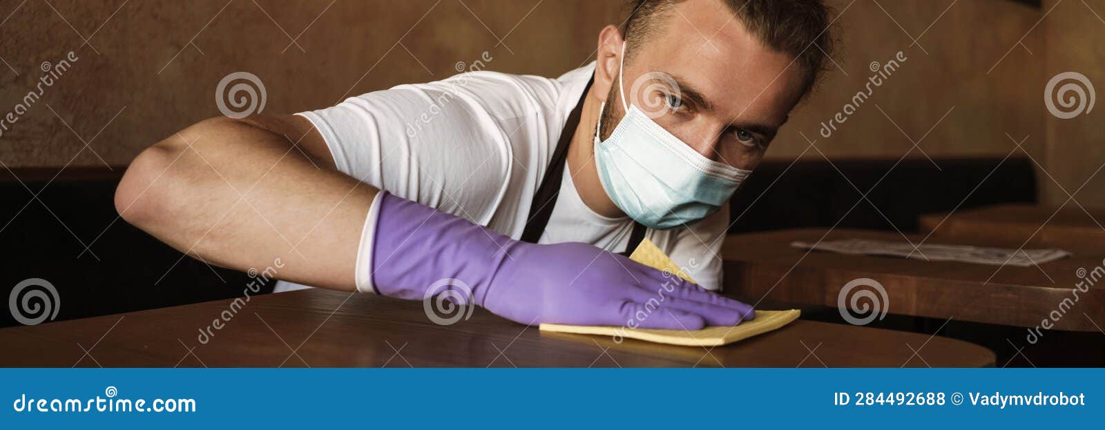 A Man Waiter in a Protective Mask Wiping a Table in a Cafe Stock Photo ...