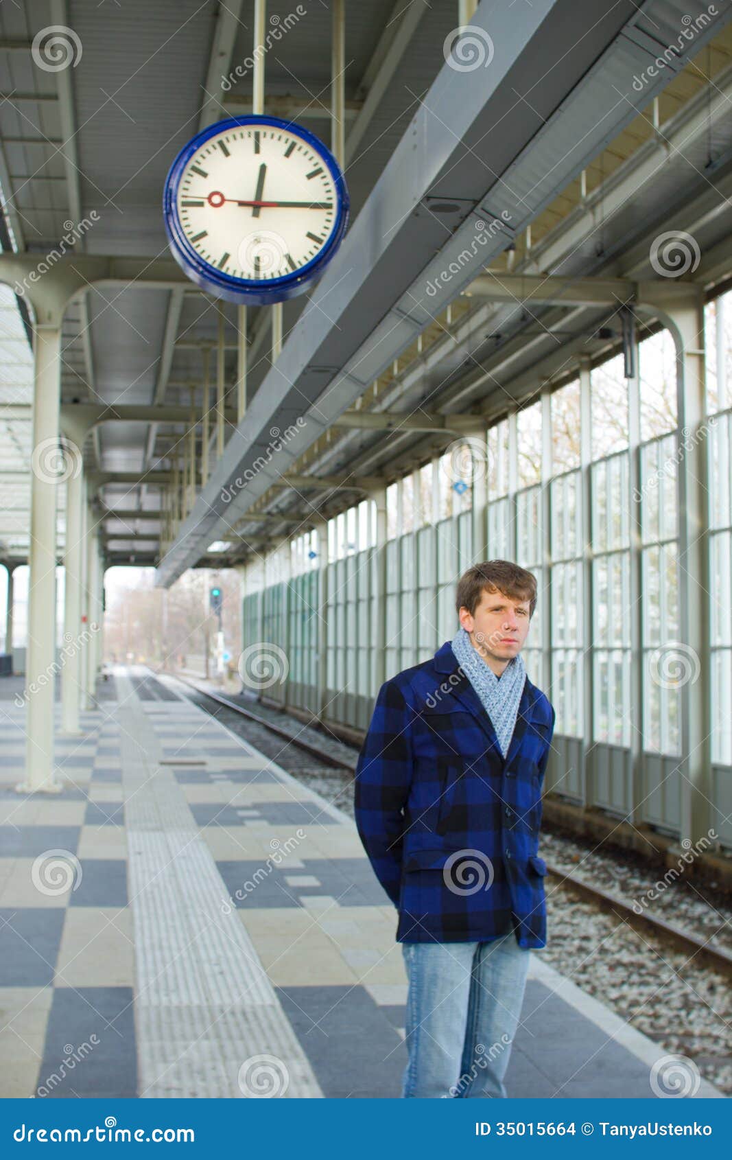 A Man Waiting for a Train Under a Clock Stock Photo - Image of serious ...