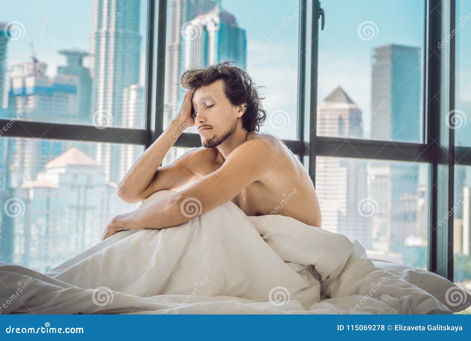 Man Wakes Up In The Morning In An Apartment In The Downtown Area Stock