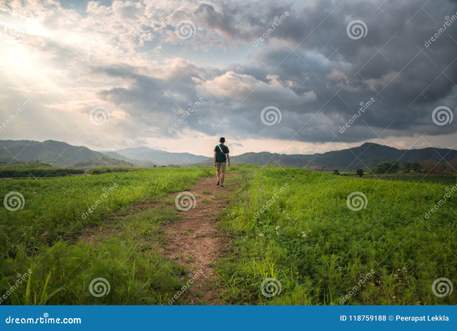 A Man Walking Alone on the Road with Dramatic Sky. Stock Photo - Image ...