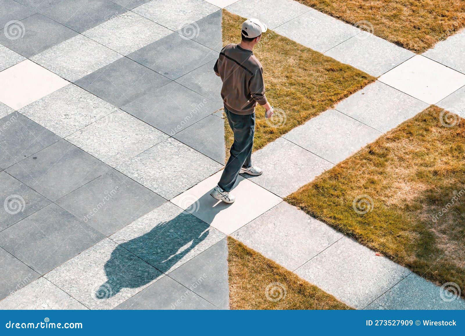 Man Walking Along a Sidewalk Symmetrically Divided between Concrete and ...