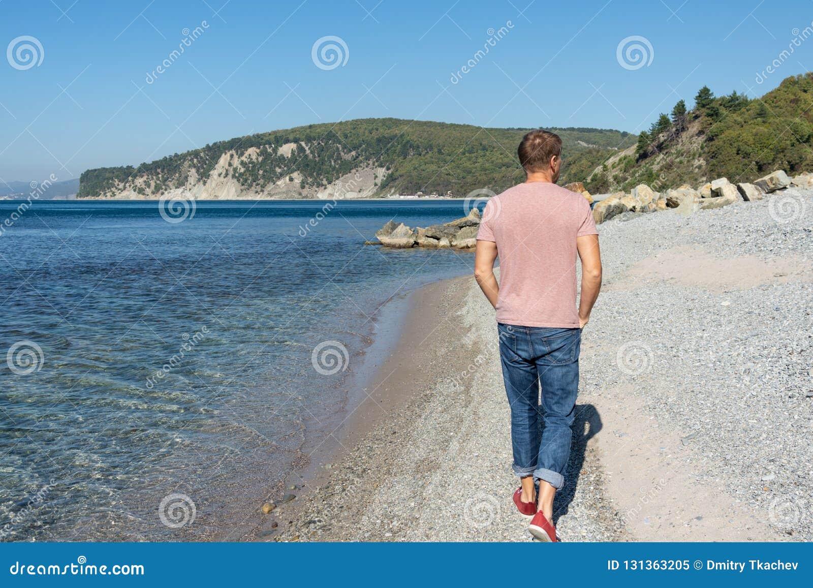 Man Walking on the Beach. Beautiful Pebble Beach, Blue Sky and Sea ...
