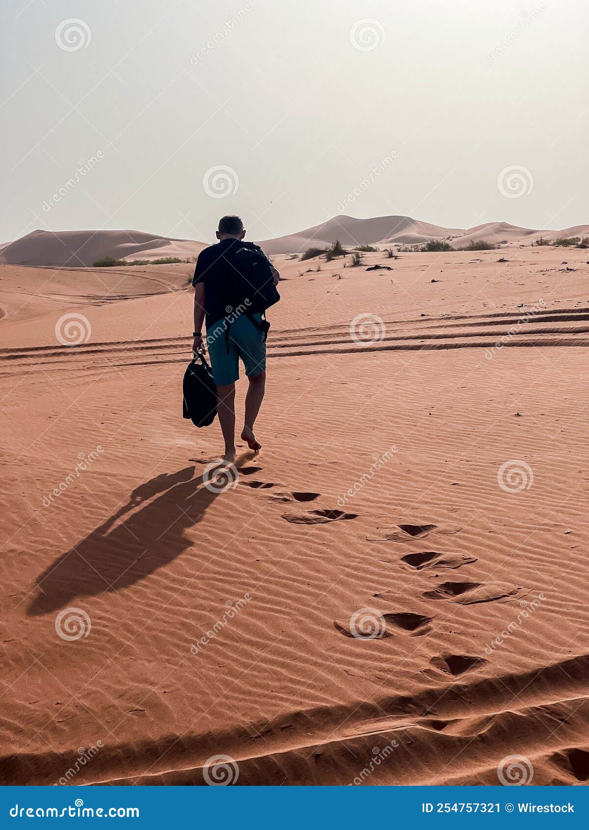 A Man Walking on Desert Sand Stock Image - Image of foot, background ...