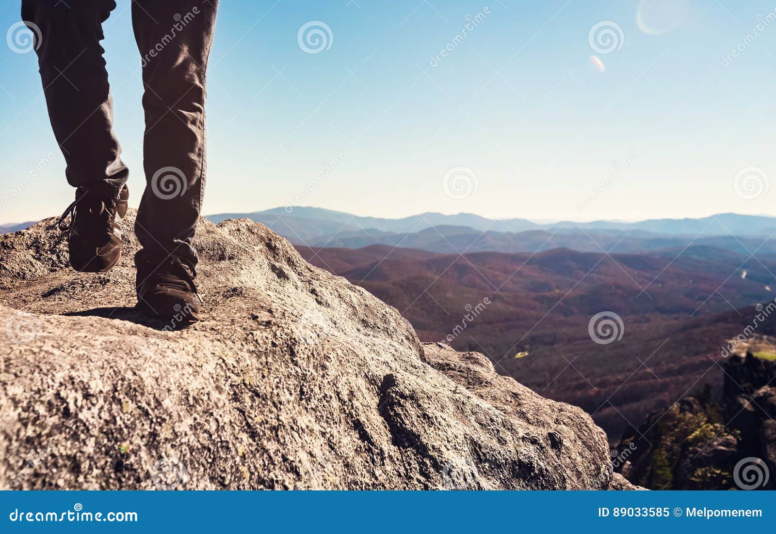 Man Walking on the Edge of a Cliff High Above the Mountains Stock Image ...