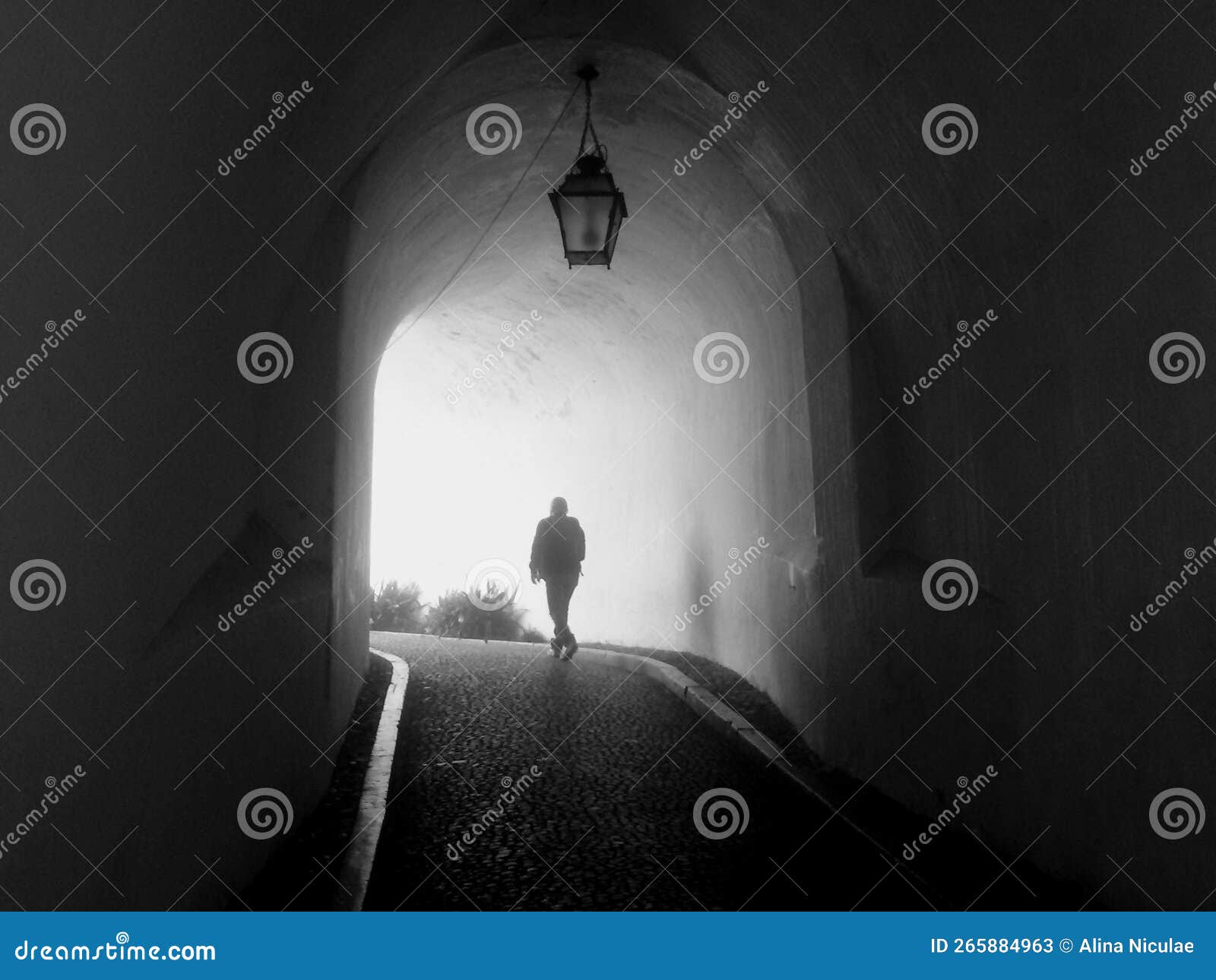 Man walking towards light stock image. Image of photograph - 265884963