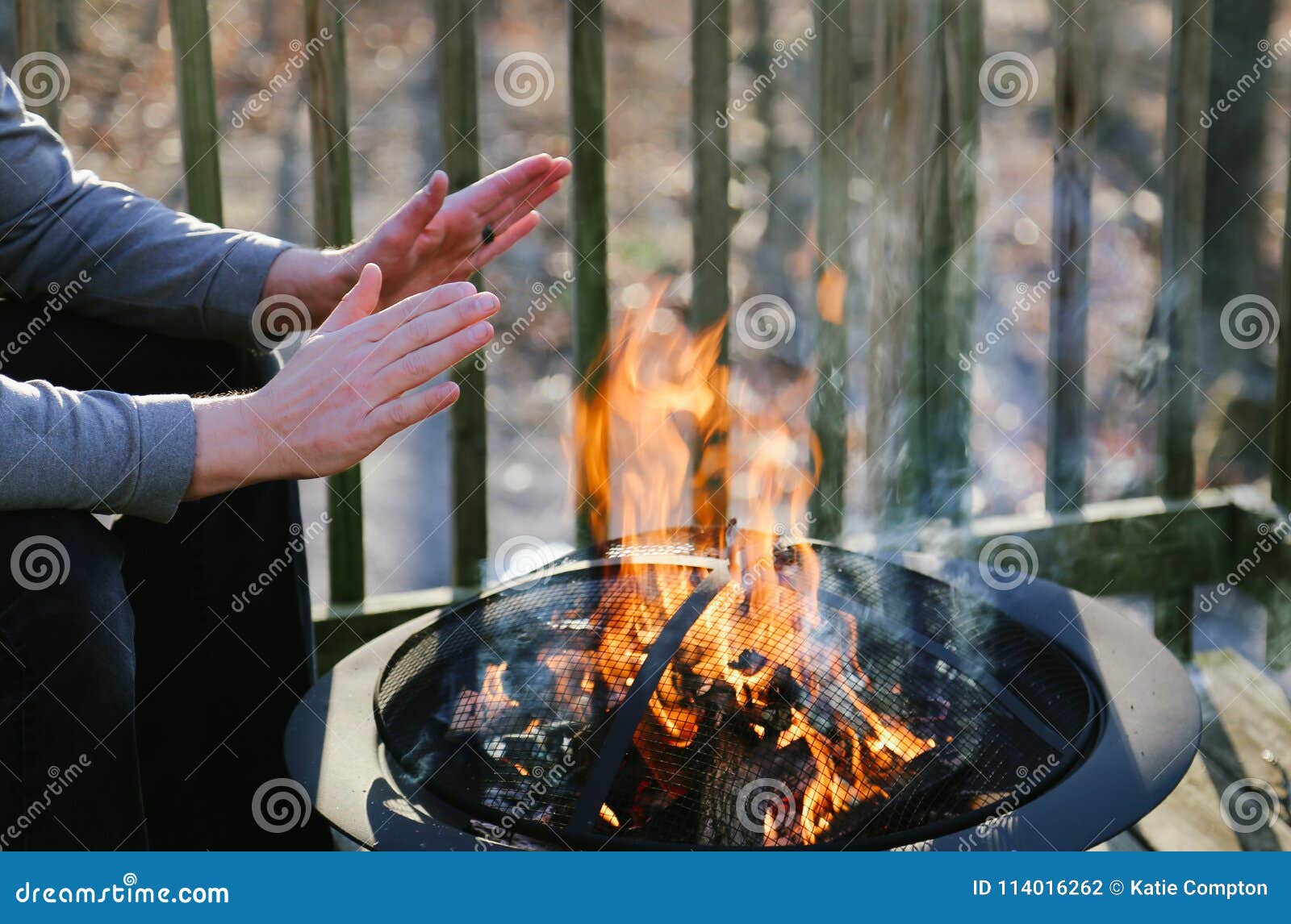 Man Warms His Hands Over a Fire Pit on a Deck. Stock Photo - Image of ...