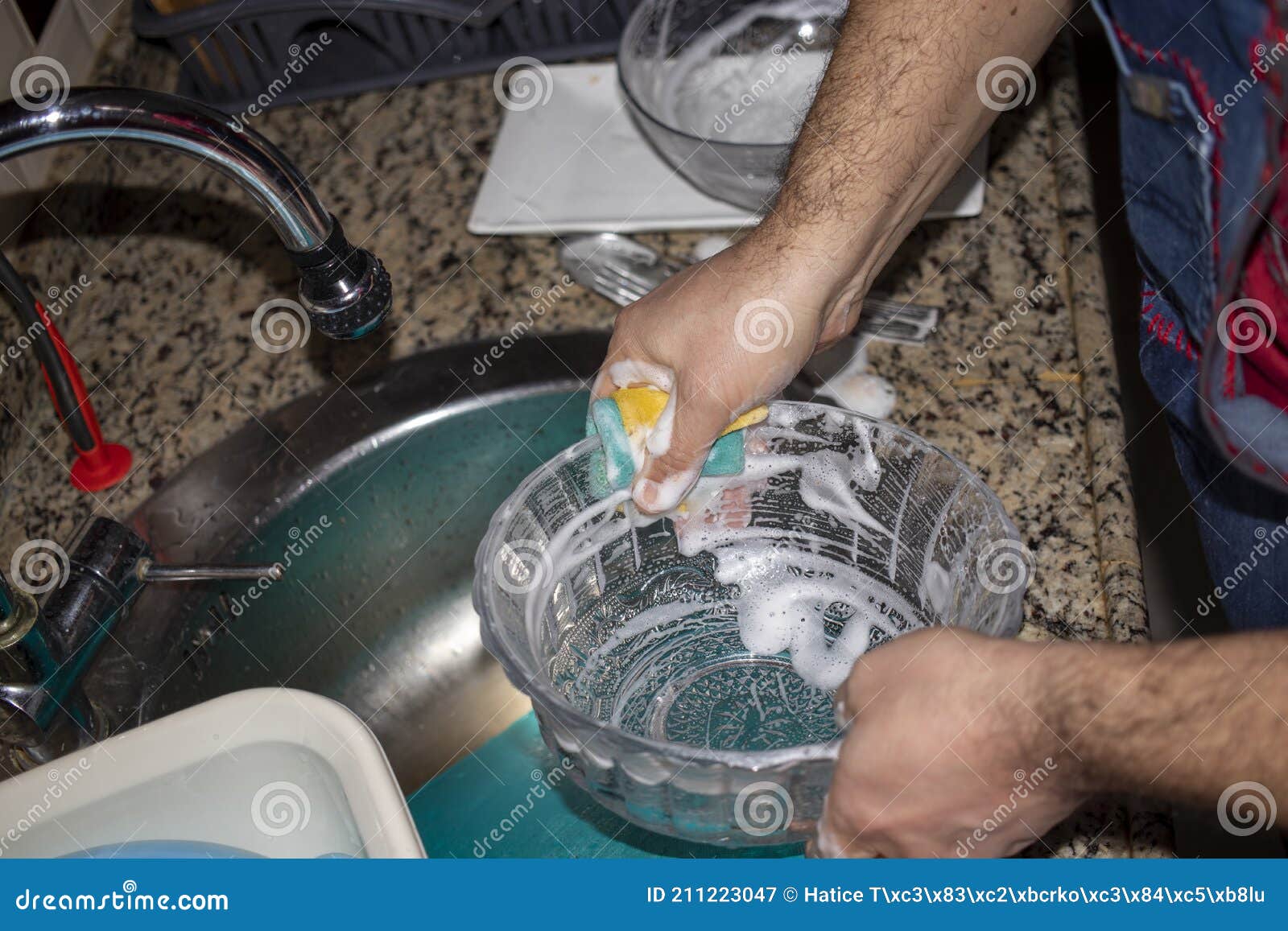 A Man Washing the Dishes by Hand in the Kitchen of His Home. Stock ...
