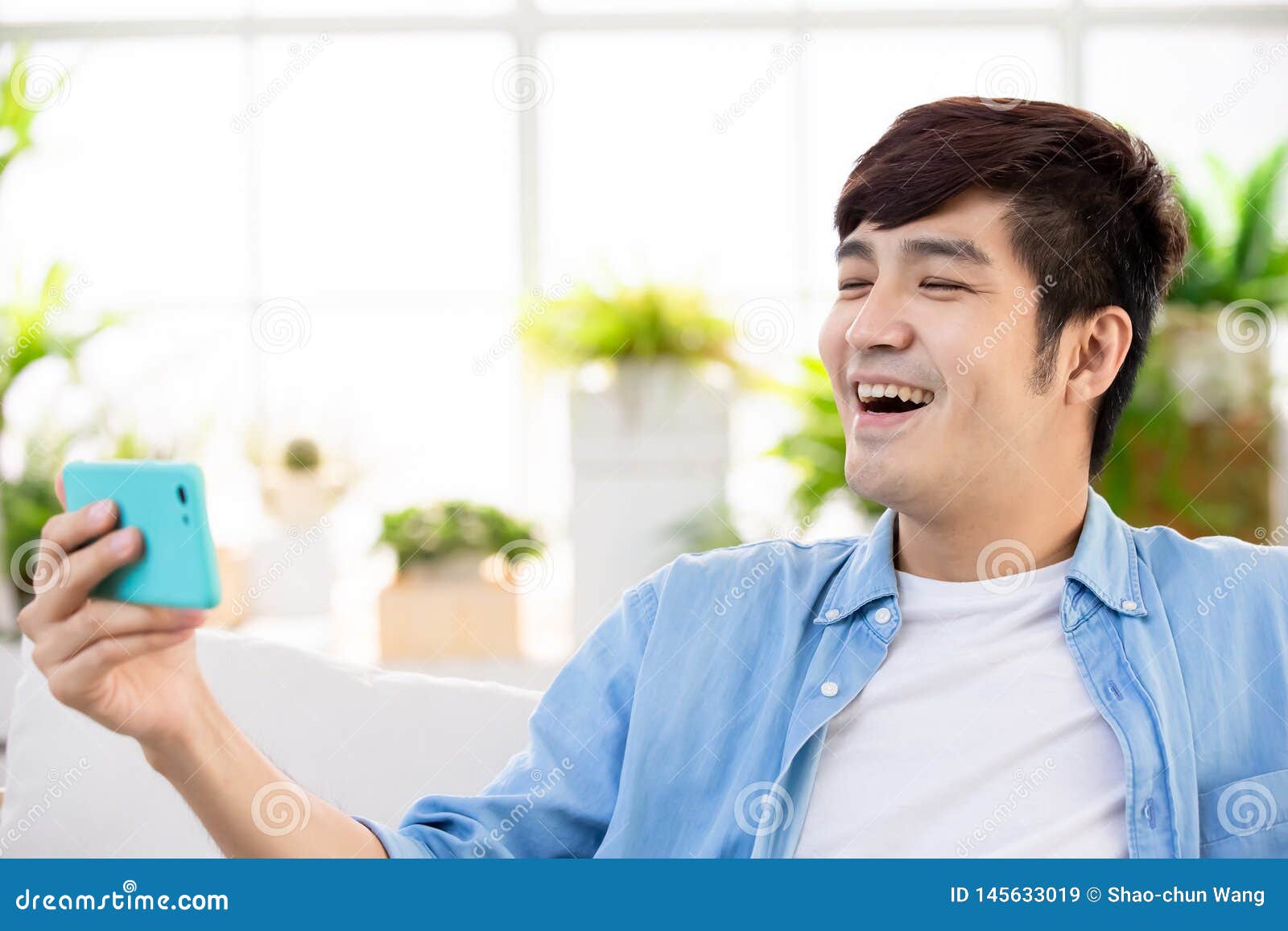 Man watch video with phone stock image. Image of couch - 145633019